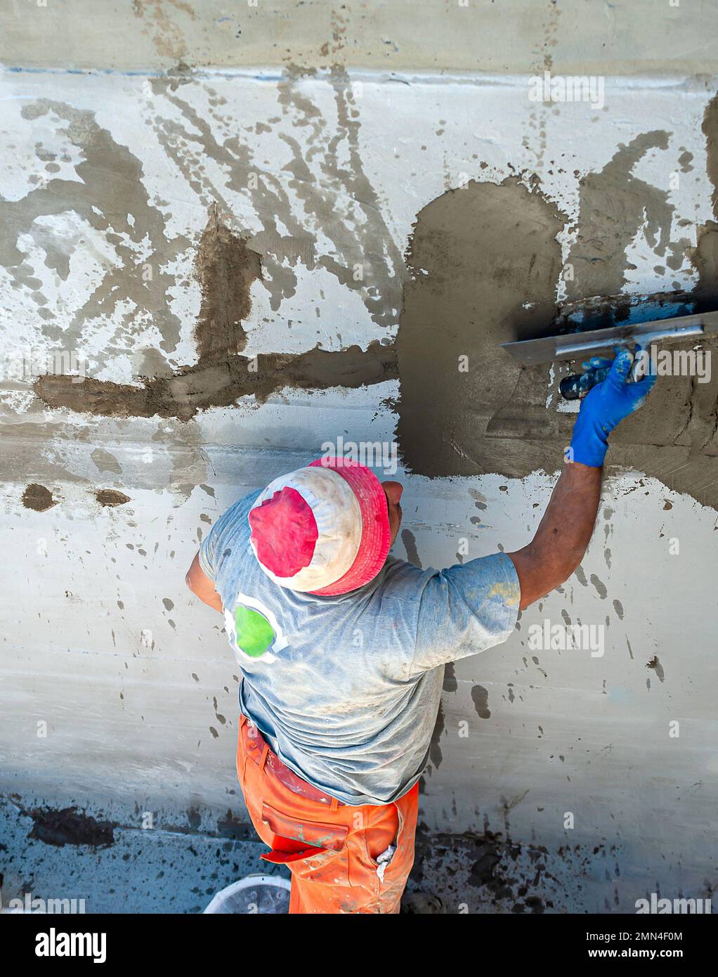 Building worker spreading mortar thixotropic on concrete wall with ...