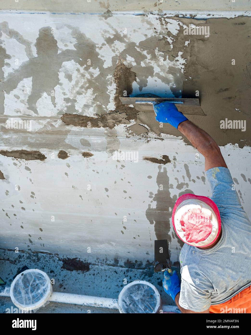 Building worker spreading mortar thixotropic on concrete wall with ...