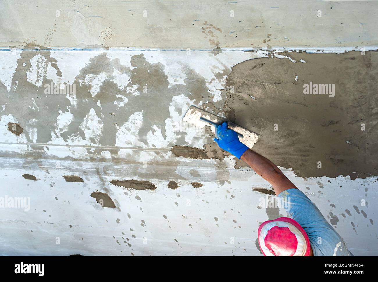 Building worker spreading mortar thixotropic on concrete wall with ...