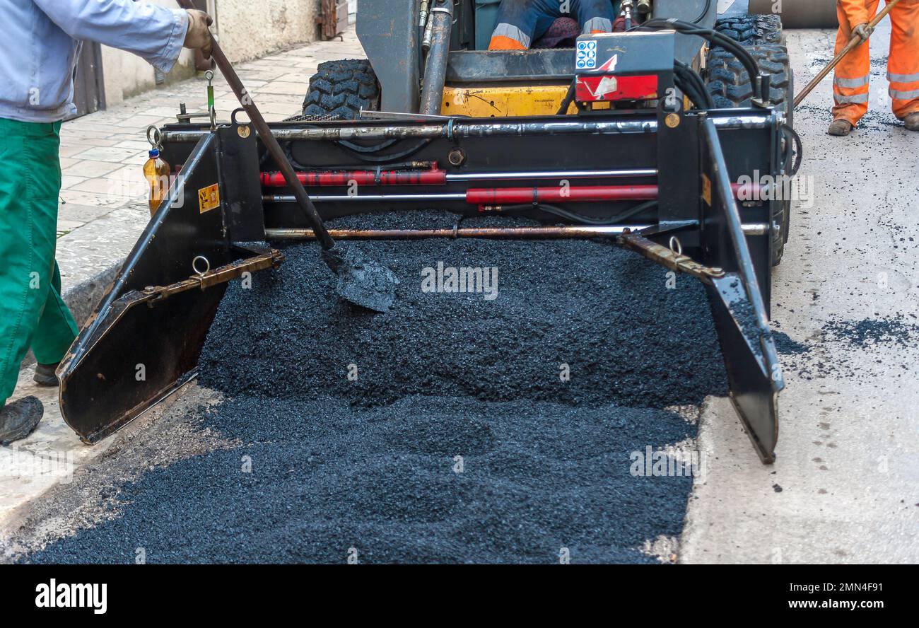 Worker on Asphalting paver machine during Road street repairing works ...
