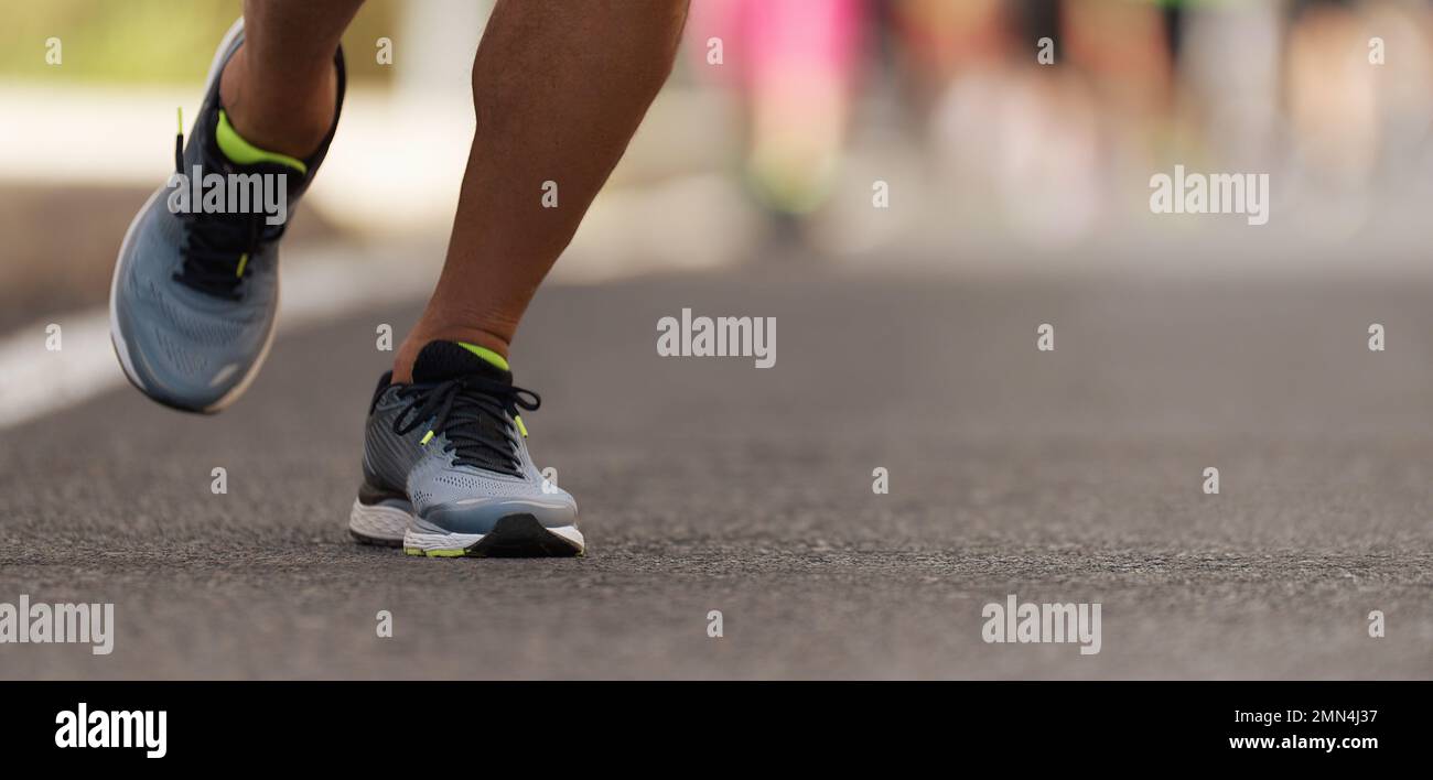 Runners feet running on road close up on shoe, male triathlete runner ...