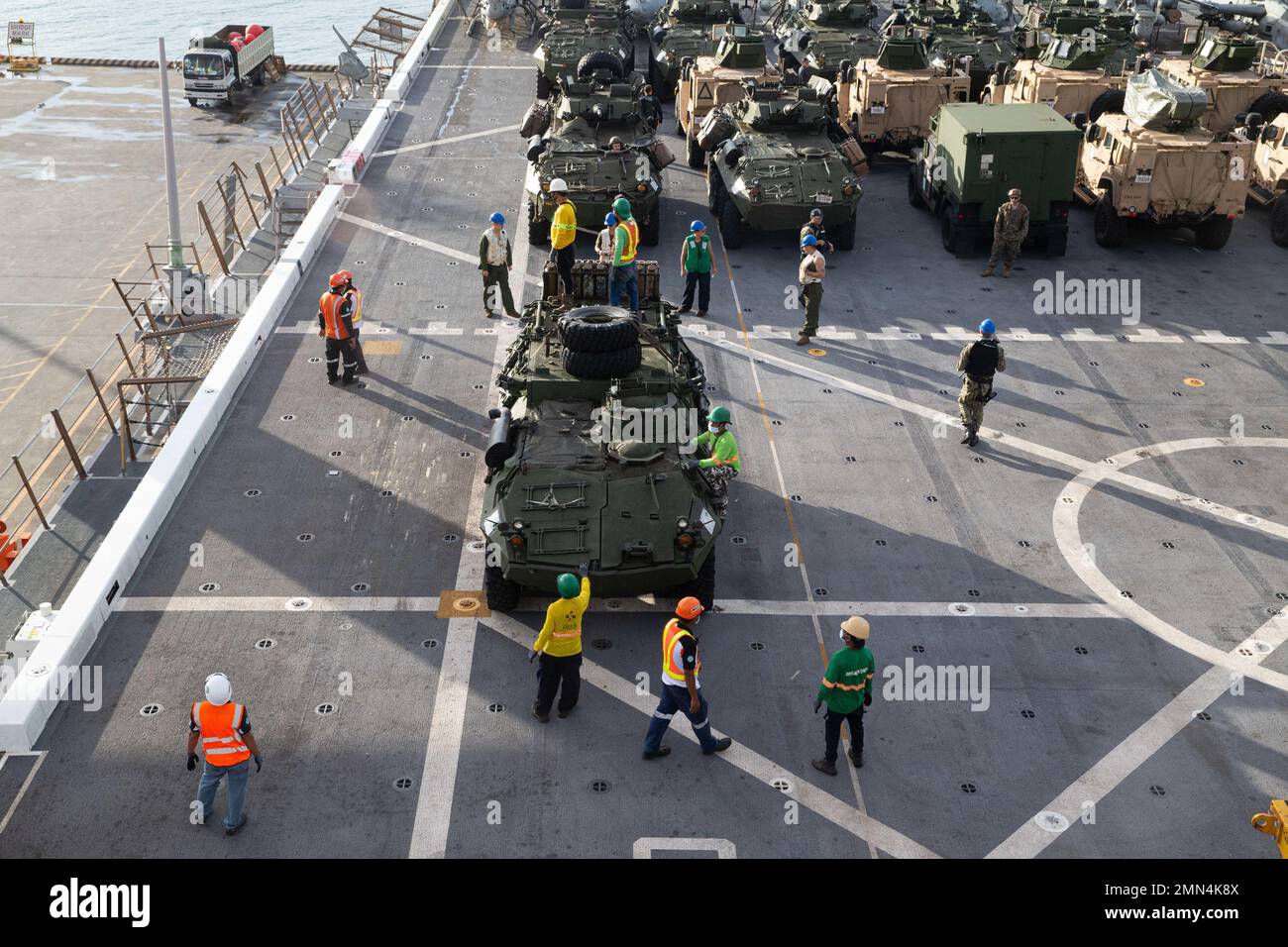 Local contractors assist with a vehicle offload in preparation for ...