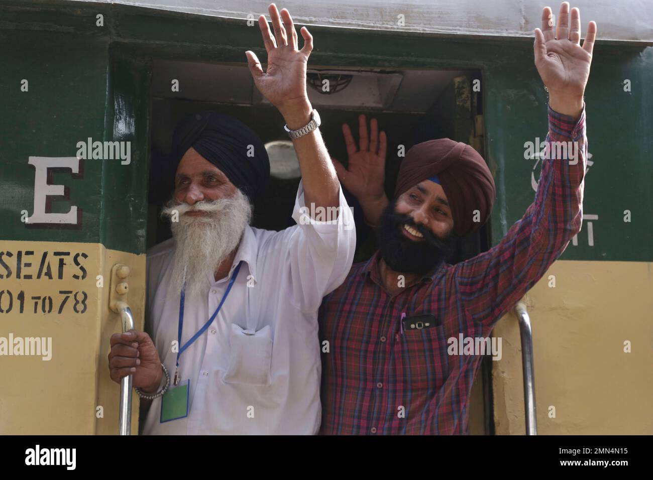 Indian Sikh wave as they arrive at Lahore railway station in Pakistan ...