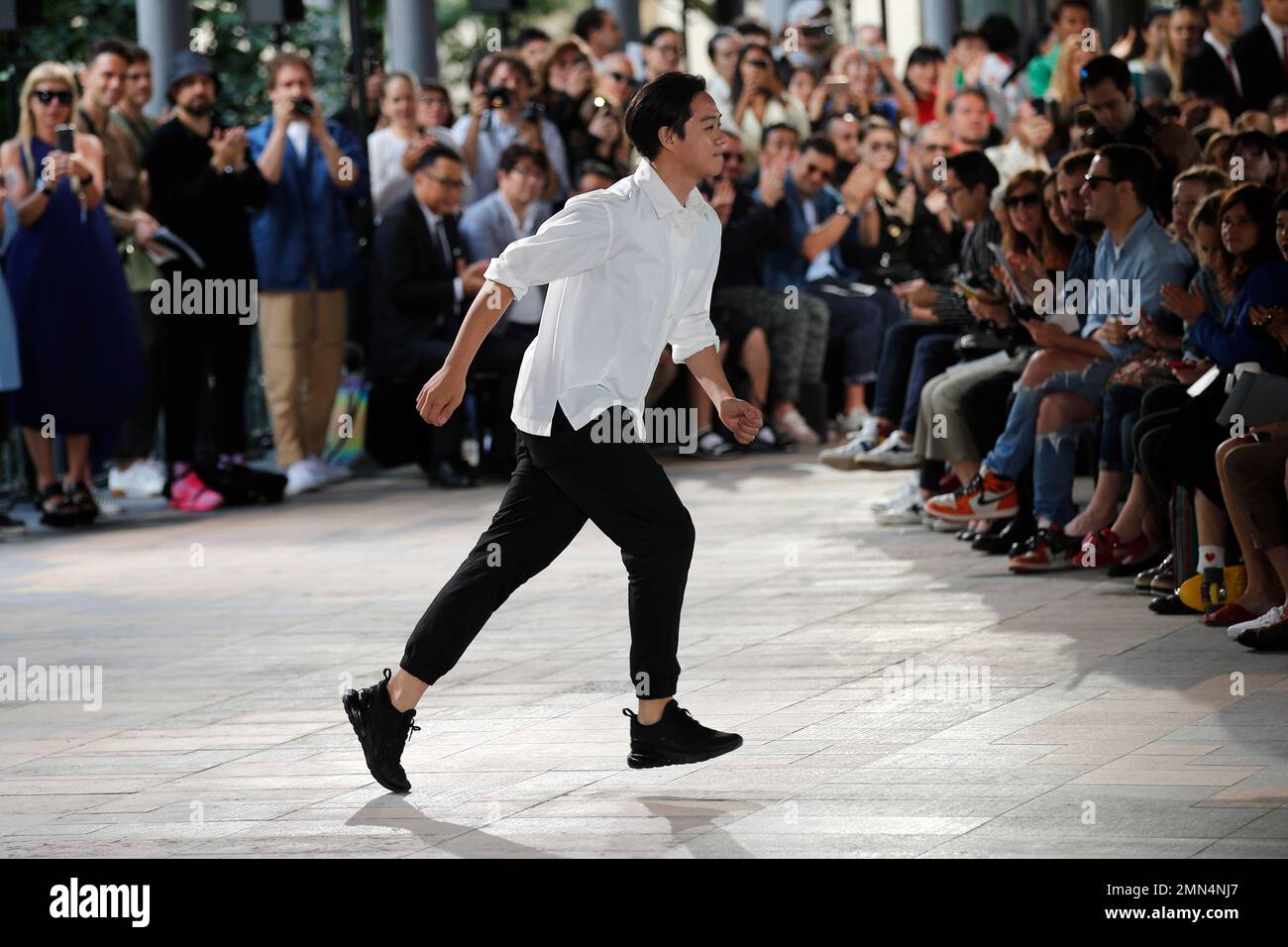 Japanese fashion designer Yusuke Takahashi runs on the catewalk after ...