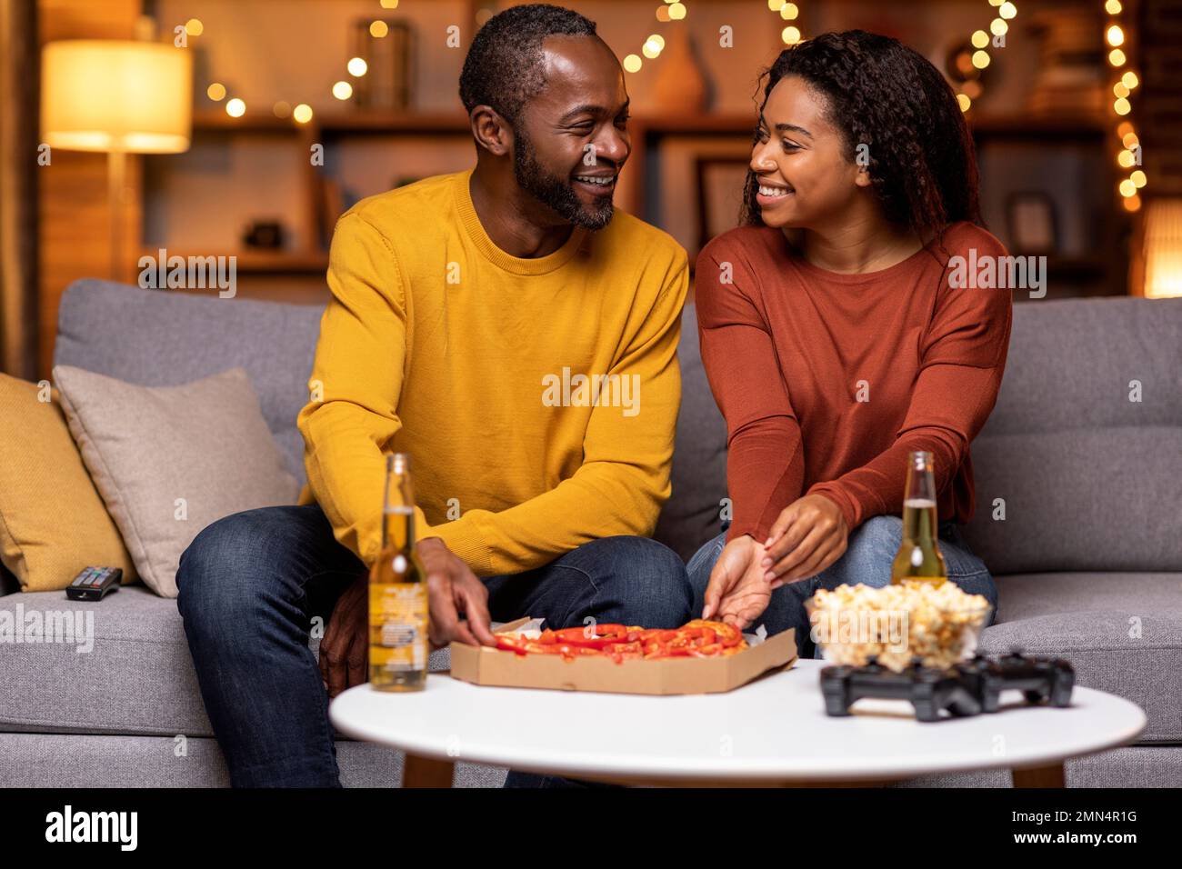 Loving cheerful black couple enjoying romantic evening at home Stock ...
