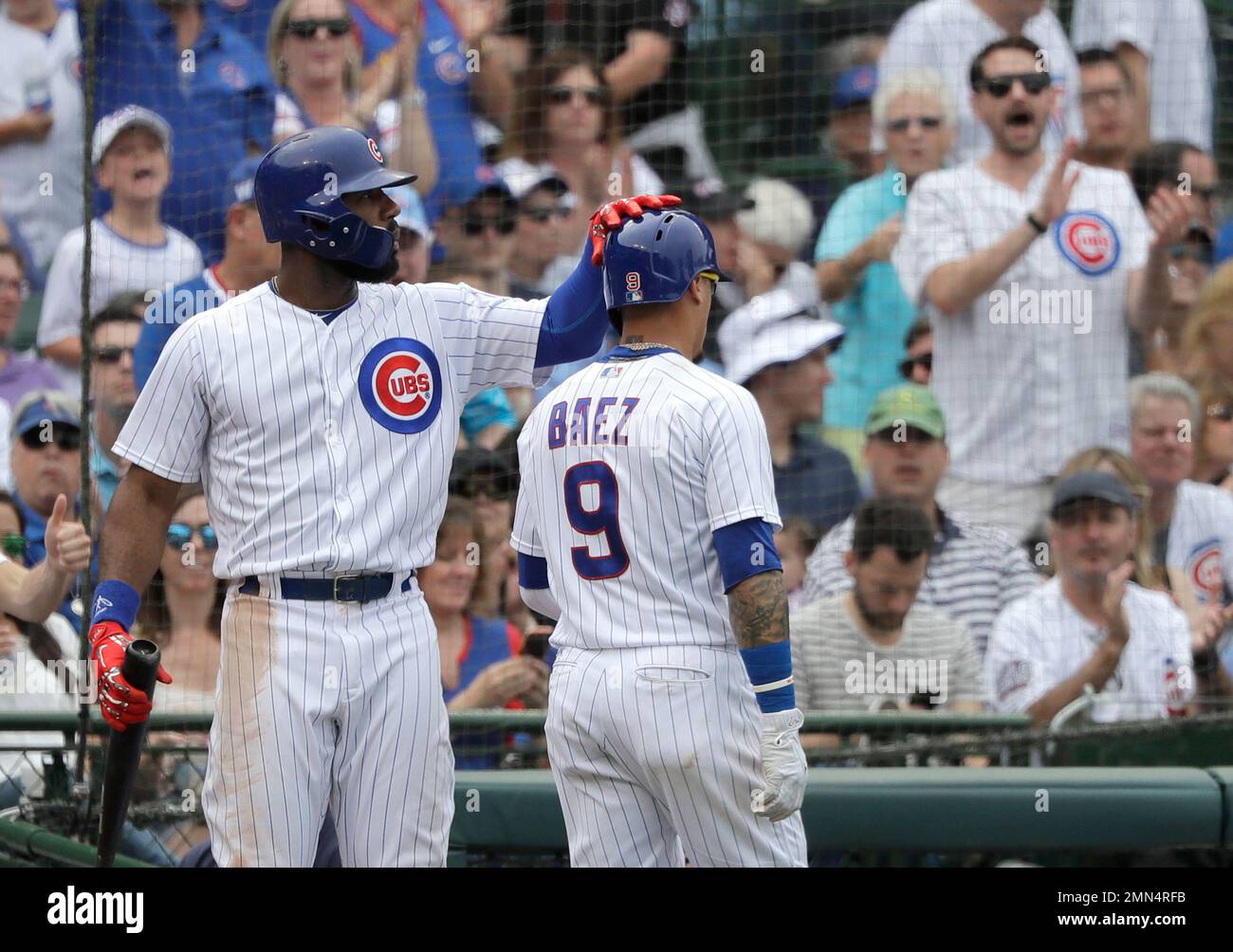 Chicago Cubs' Jason Heyward, left, pats Javier Baez on the helmet after ...