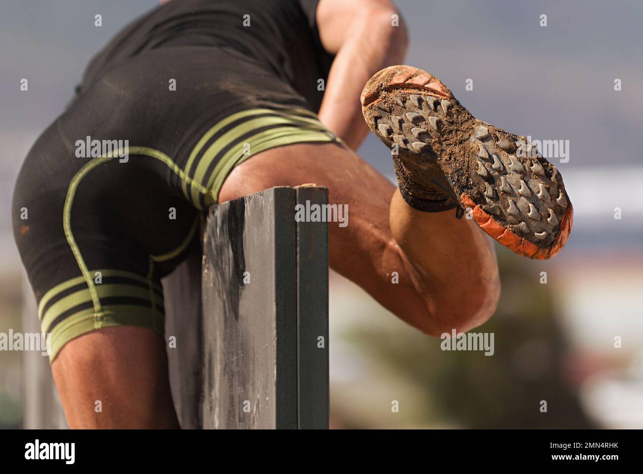 Mud race runners running over obstacles extreme sport Stock Photo - Alamy