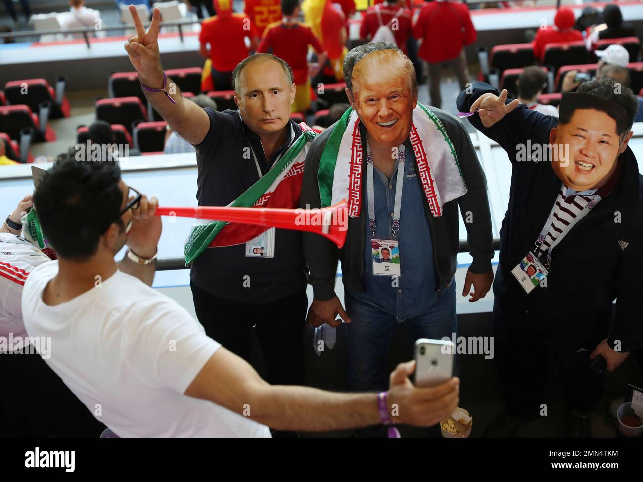 Iran fans wear masks representing, from right, North Korean leader Kim ...