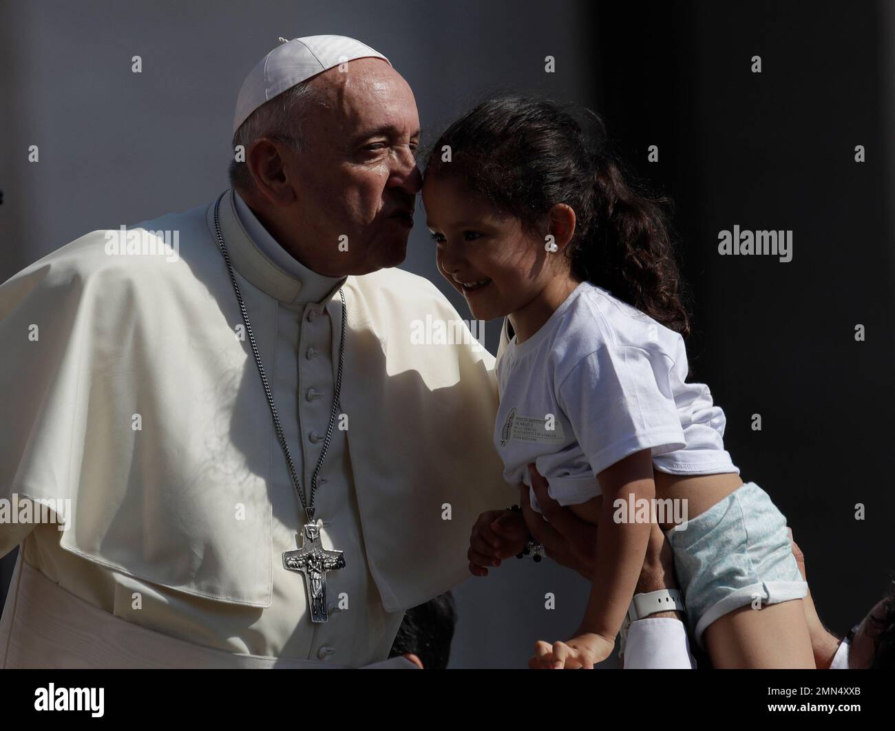 Pope Francis kisses a baby as arrives in St. Peter's Square at the ...