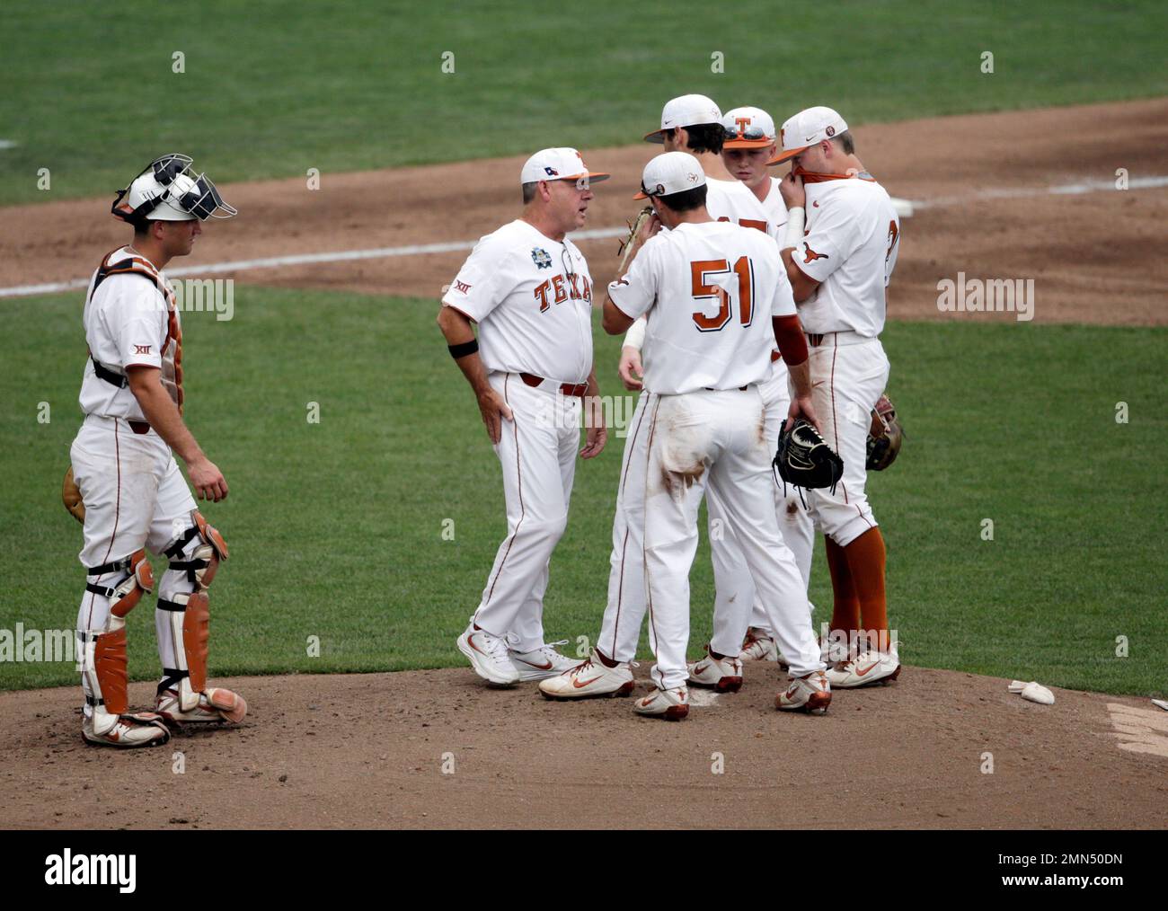 Texas coach David Pierce talks to his players on the mound in the ...