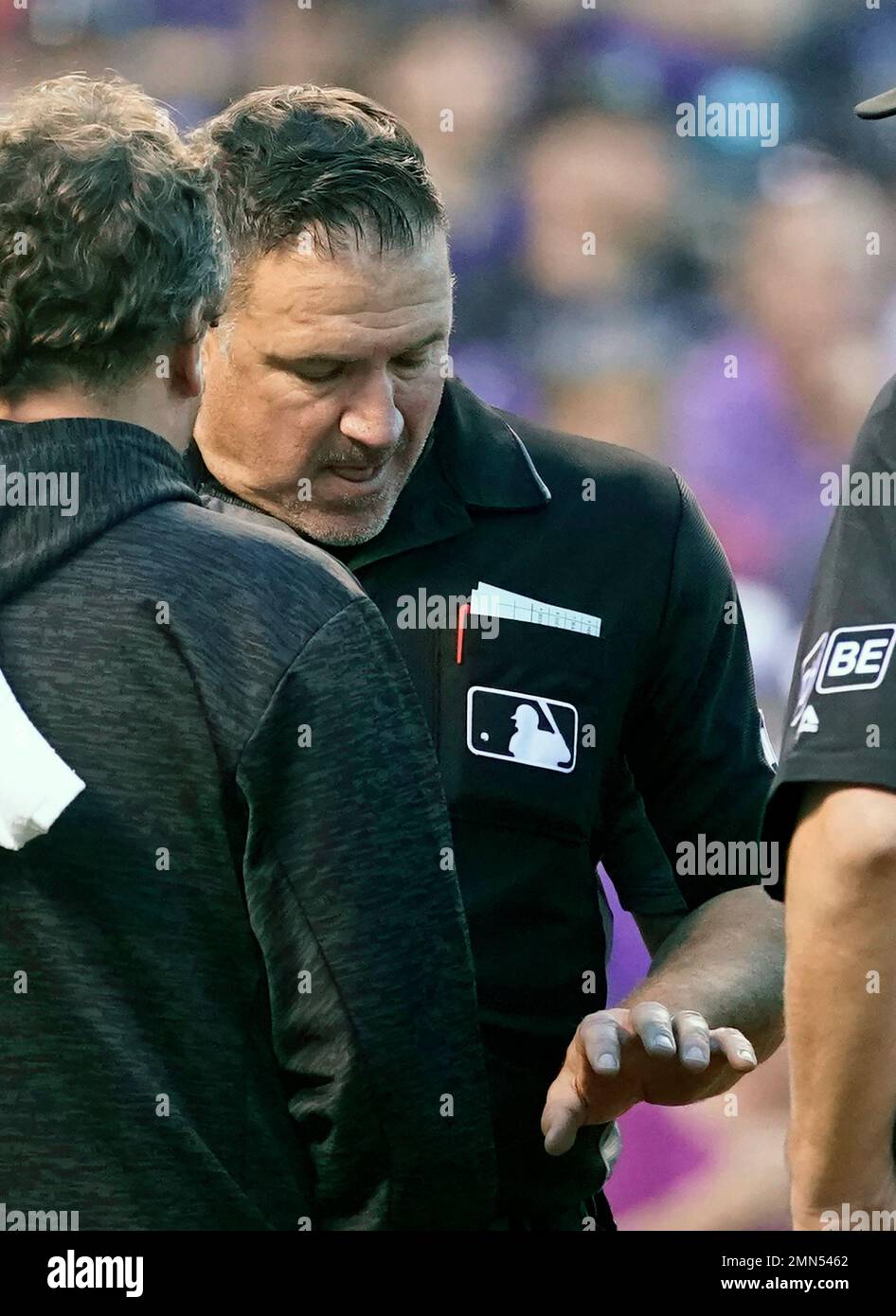 Home plate umpire Tony Randazzo is tended to by a trainer after getting ...