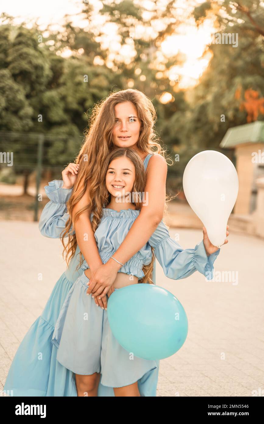 Mother daughter sunset. in blue dresses with flowing long hair a Stock ...