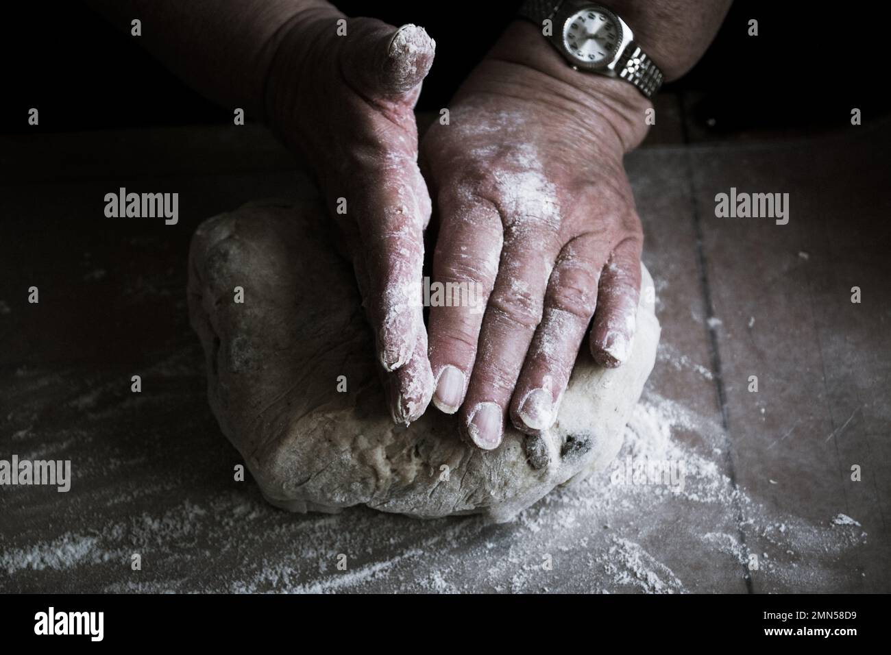 Woman Grandmother's Hands Cutting Bread Dough on a floured surface ...