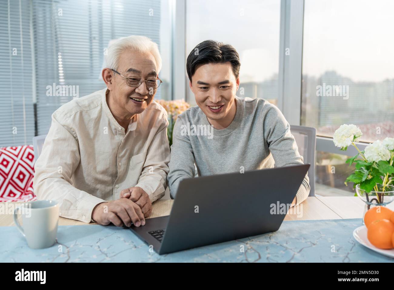 Happy father and son use notebook computer Stock Photo - Alamy