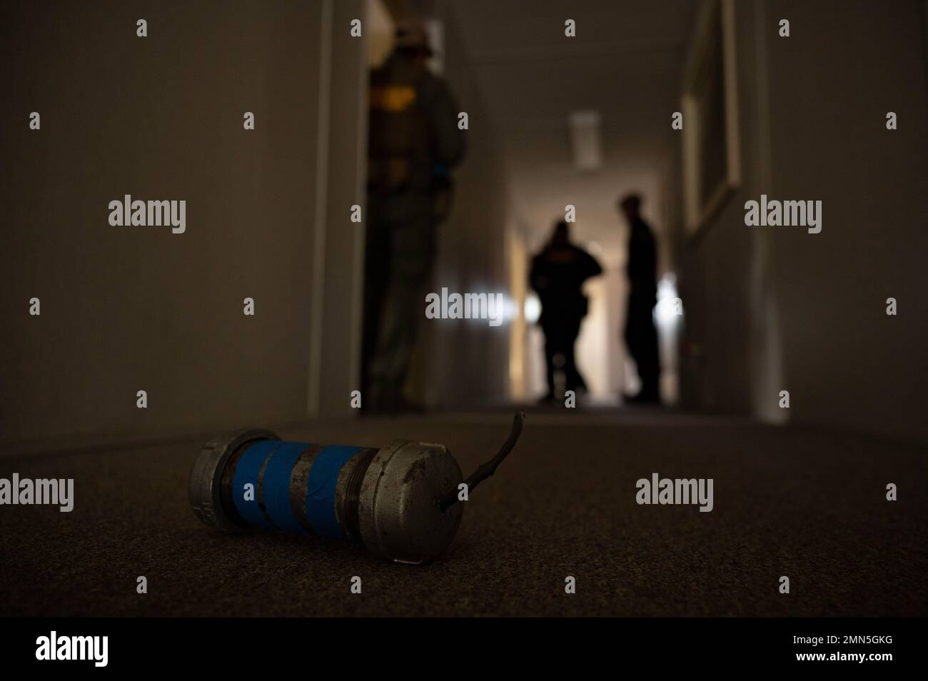 Law enforcement officers walk through a building rigged with model ...