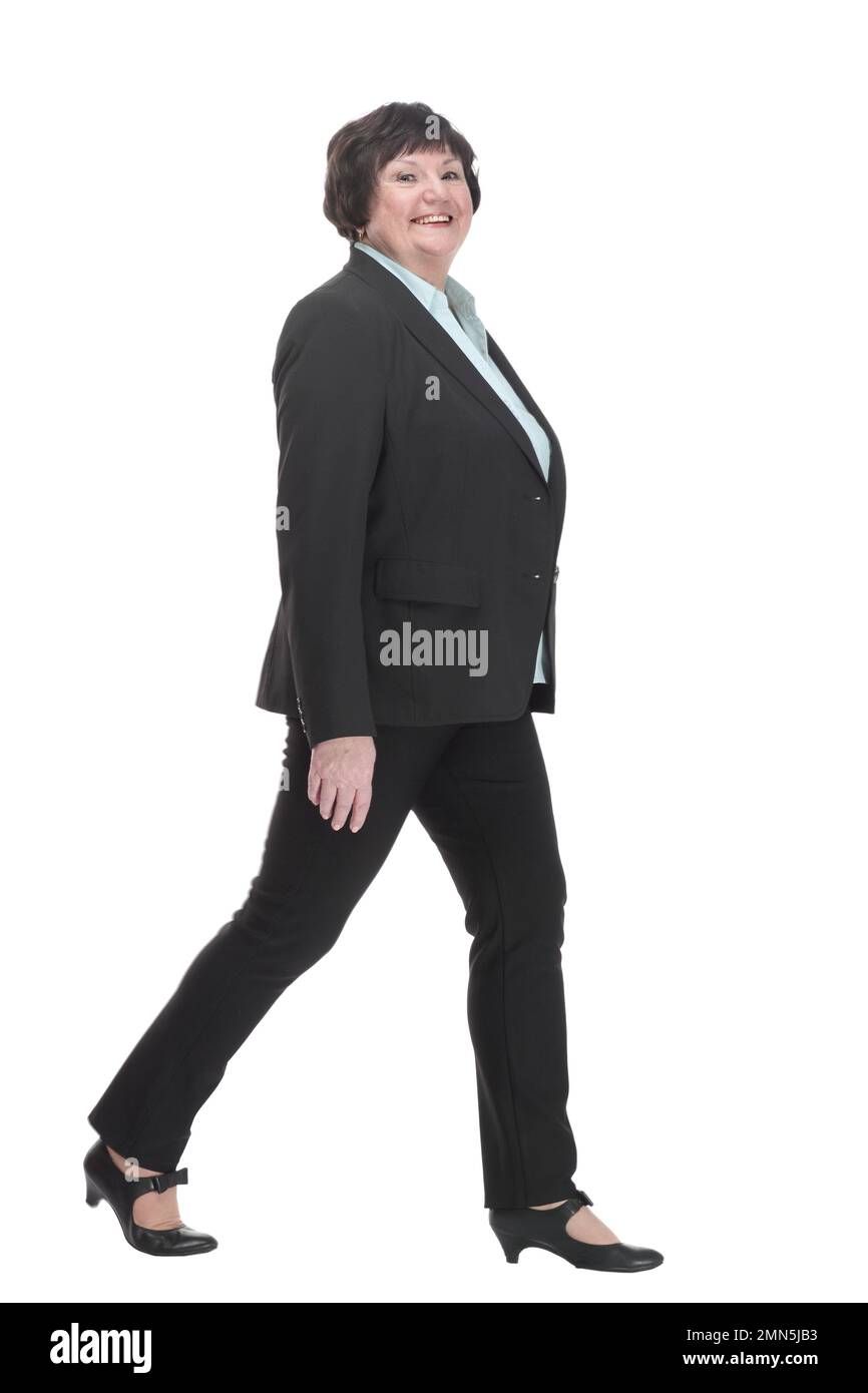 Mature business woman in a pantsuit striding forward Stock Photo - Alamy