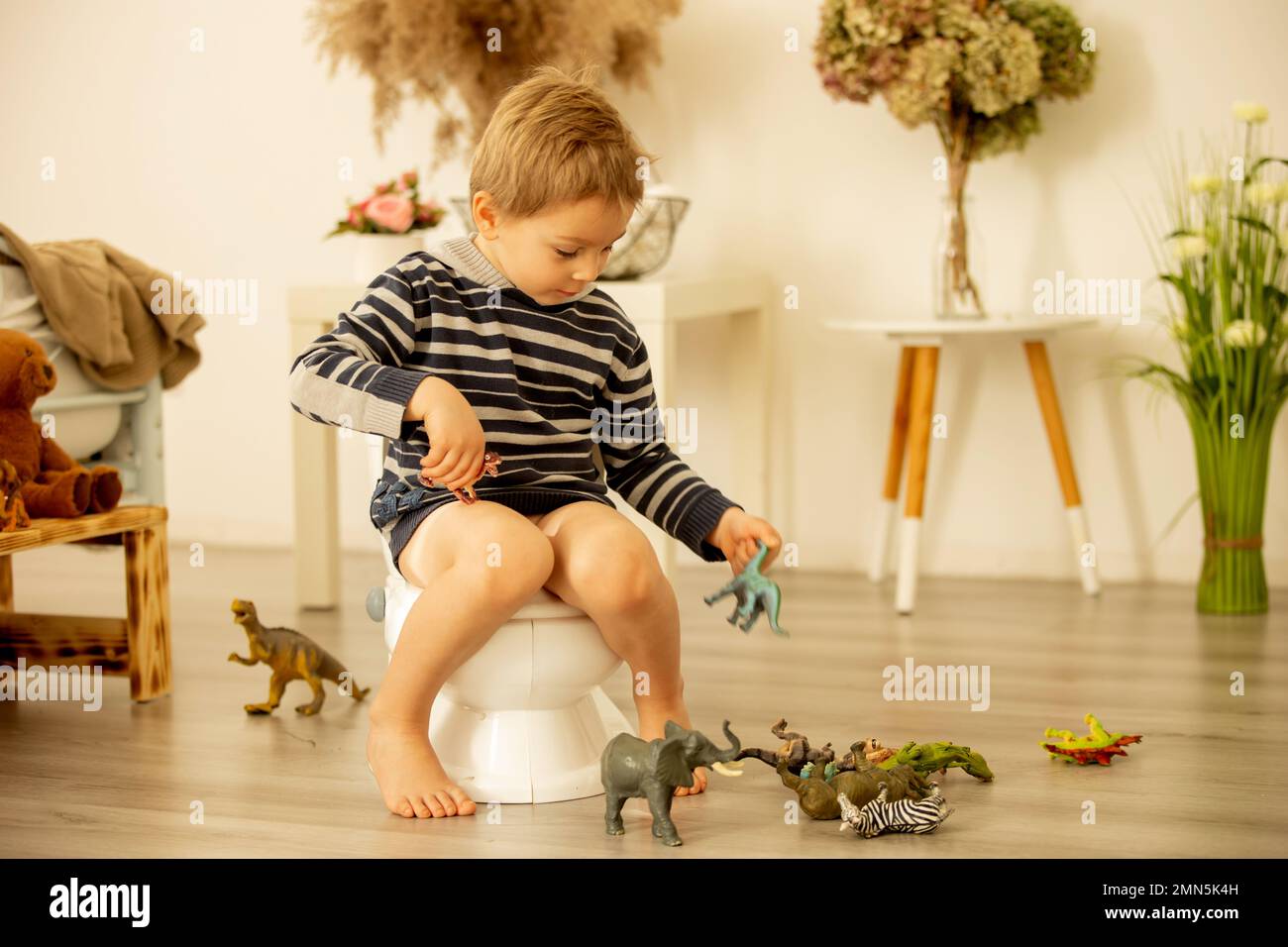 Cute toddler child, boy, using potty at home, while playing with toys ...