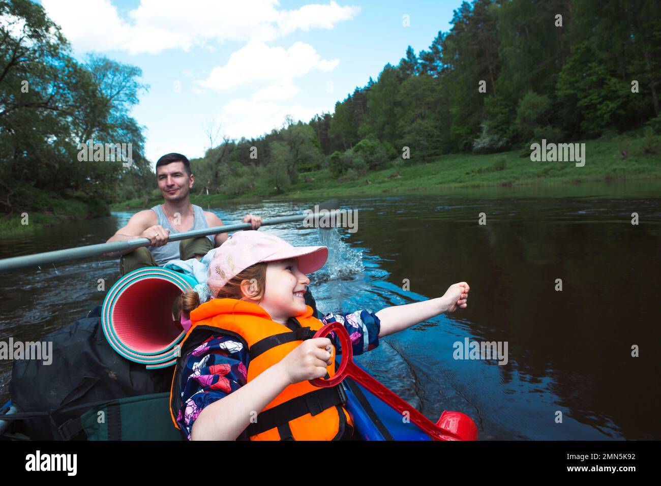 Family kayak trip. Father and daughter rowing boat on the river, a ...