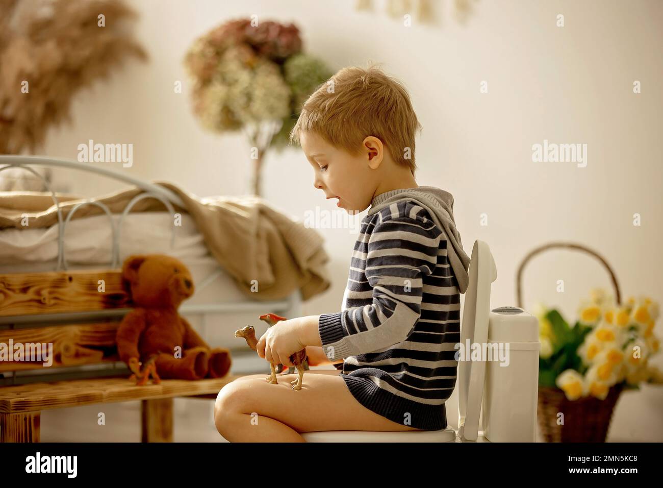 Cute toddler child, boy, using potty at home, while playing with toys ...