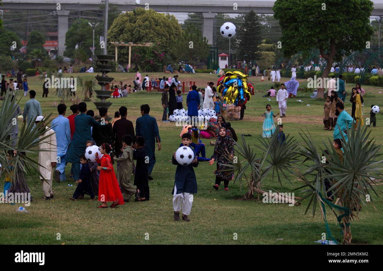 Pakistani children play with balls while they visit a park to celebrate ...
