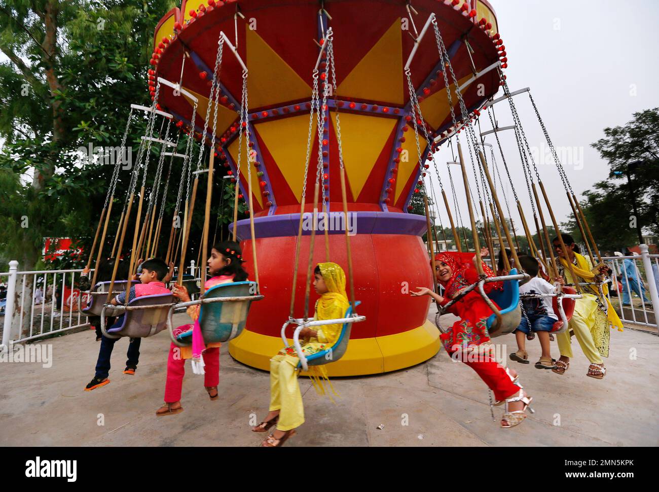 Children enjoy a ride at a fair to celebrate the Eid al-Fitr holidays ...