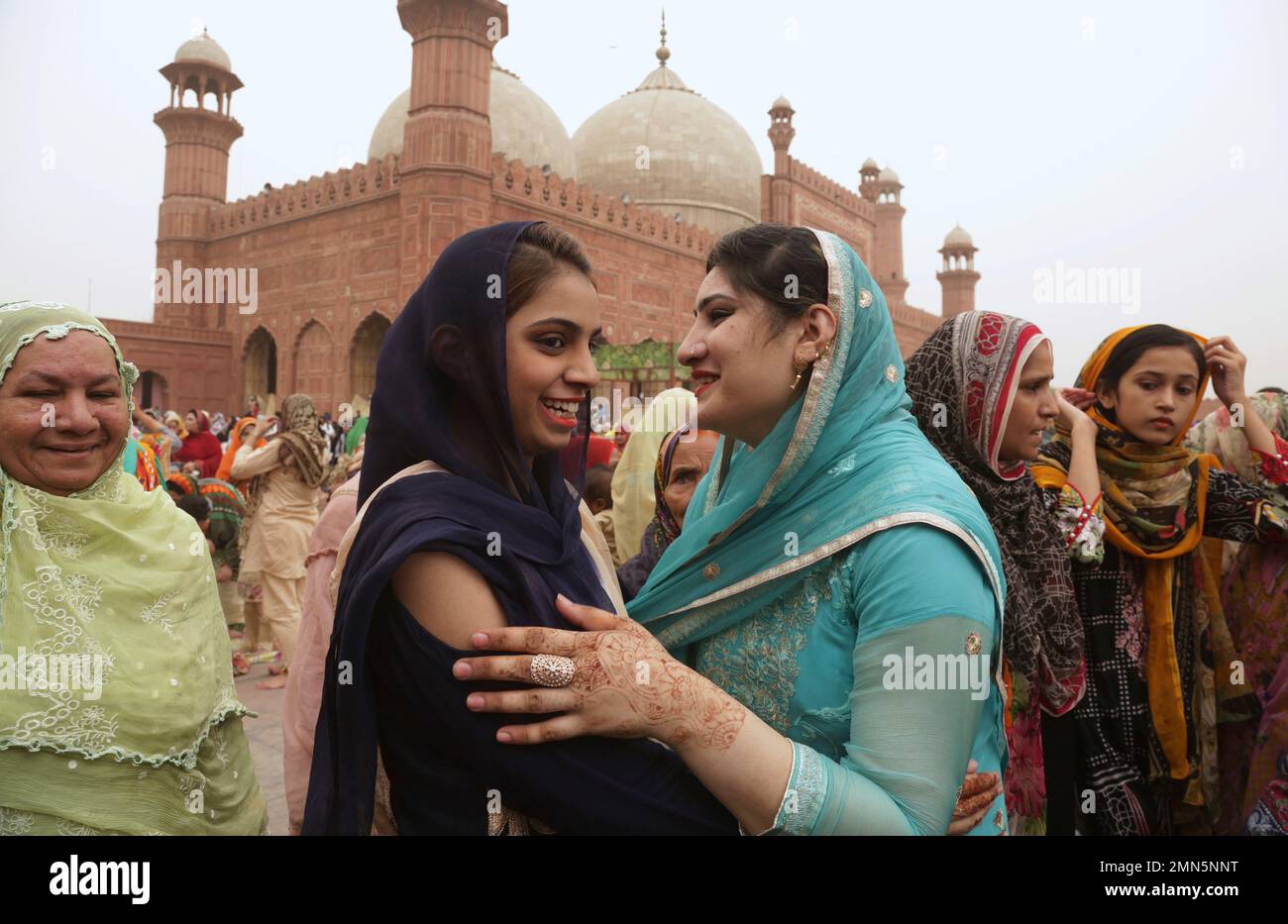 Pakistani women greet each other after offering Eid al-Fitr prayers to ...