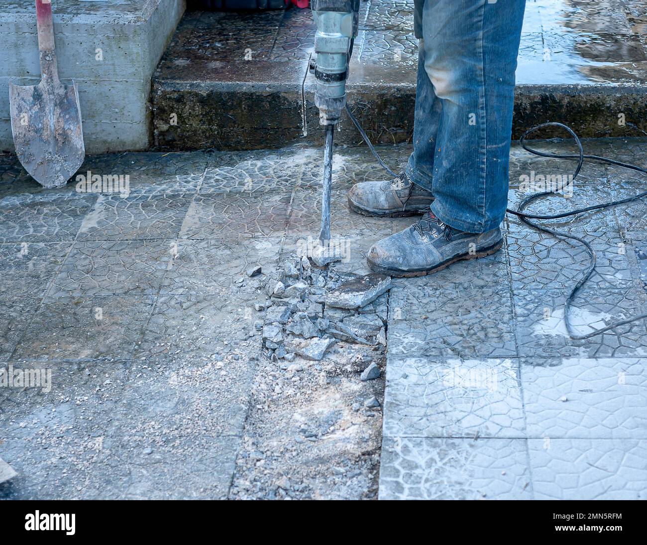 The construction worker is drilling the floor. Construction technicians ...
