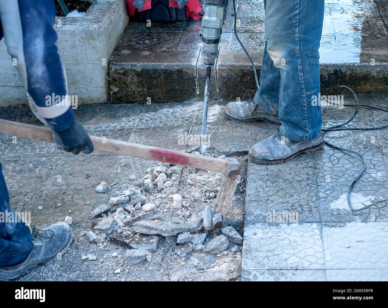 The construction worker is drilling the floor. Construction technicians ...