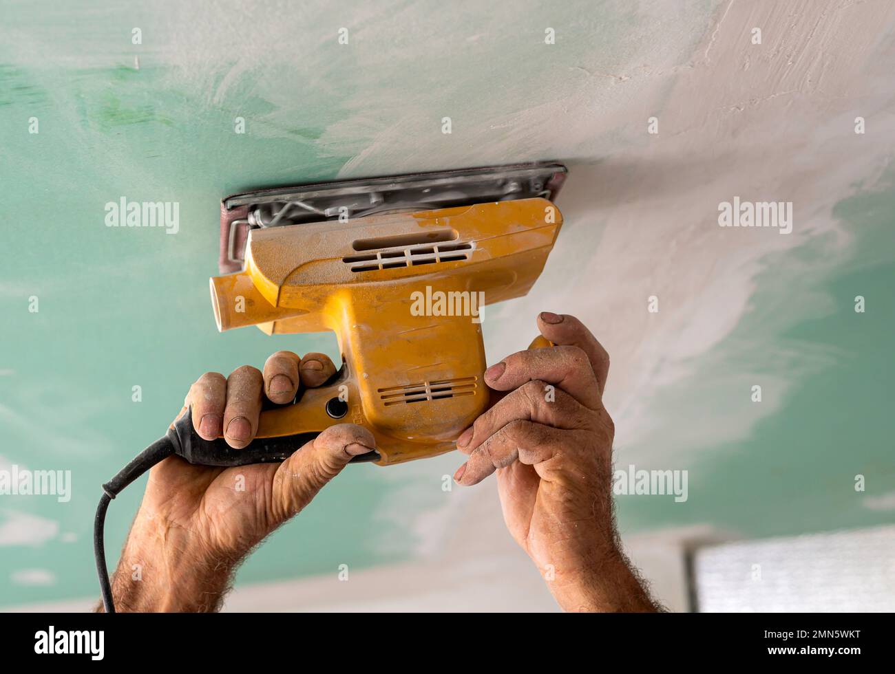 Man putting up a plasterboard ceiling Stock Photo - Alamy