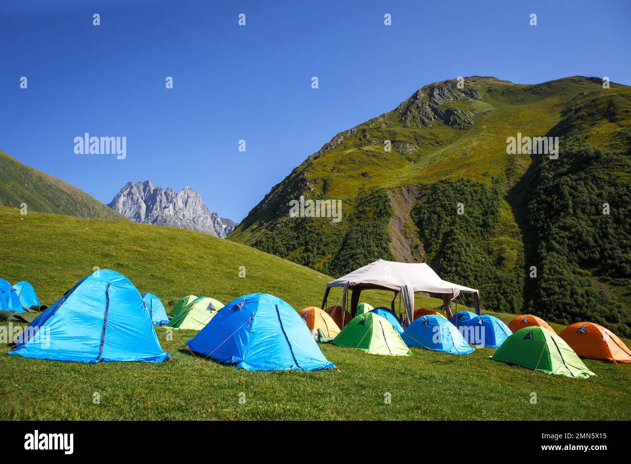 Tourist camping in the mountains of many tents and shelters for ...