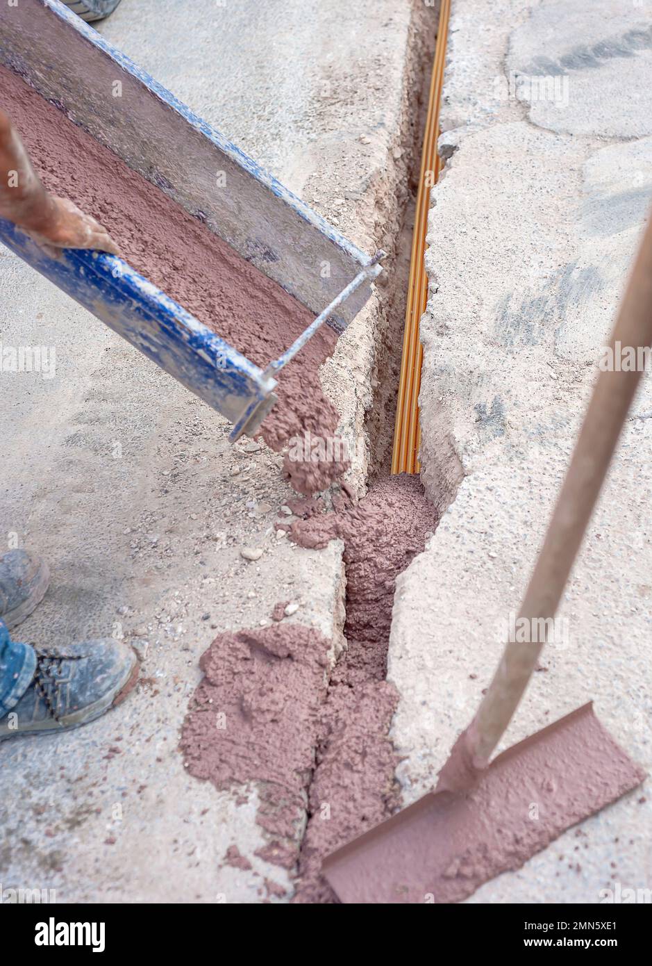 Filling with colored concrete of excavation with a narrow section for ...