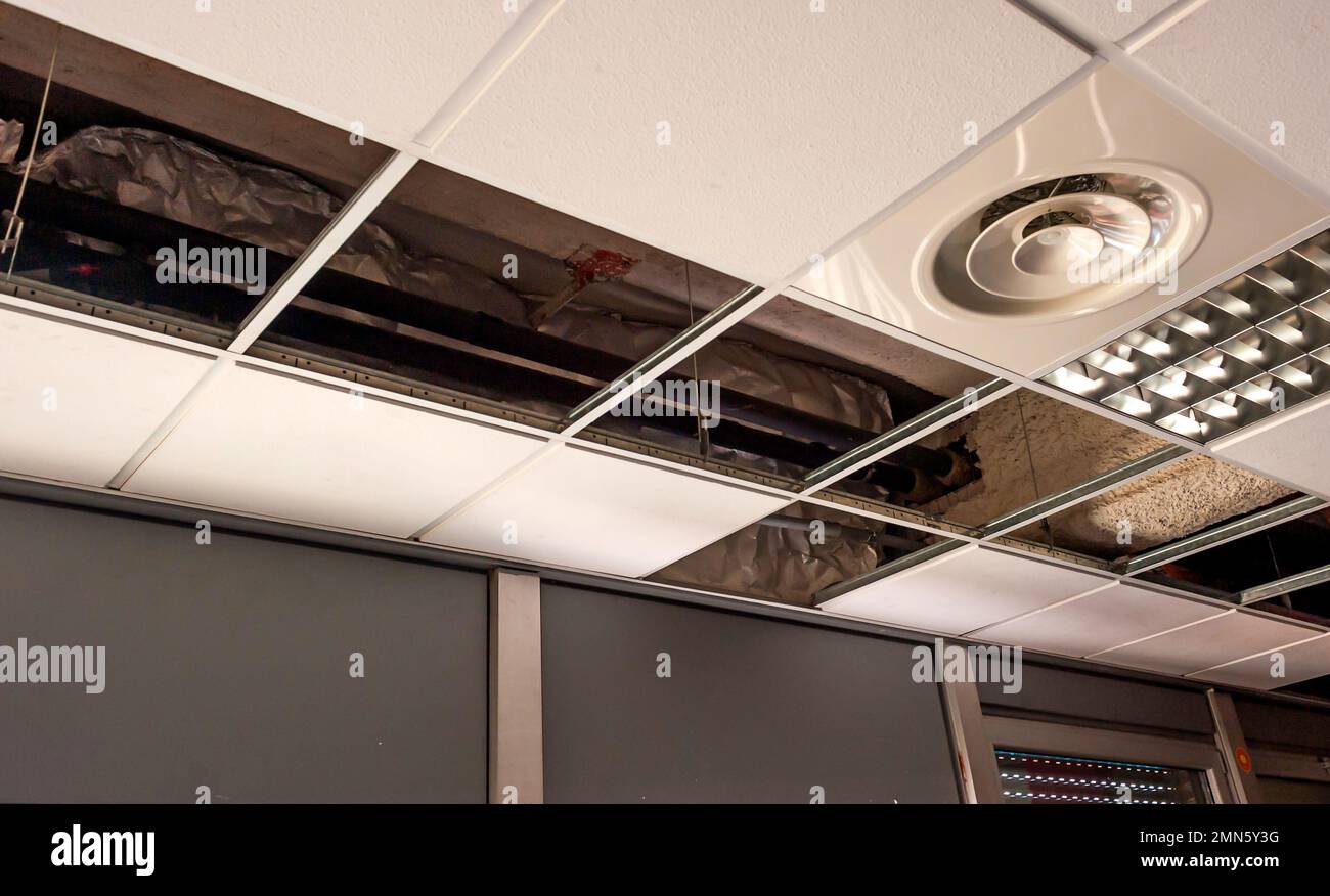 Construction worker assemble a suspended ceiling with drywall and ...