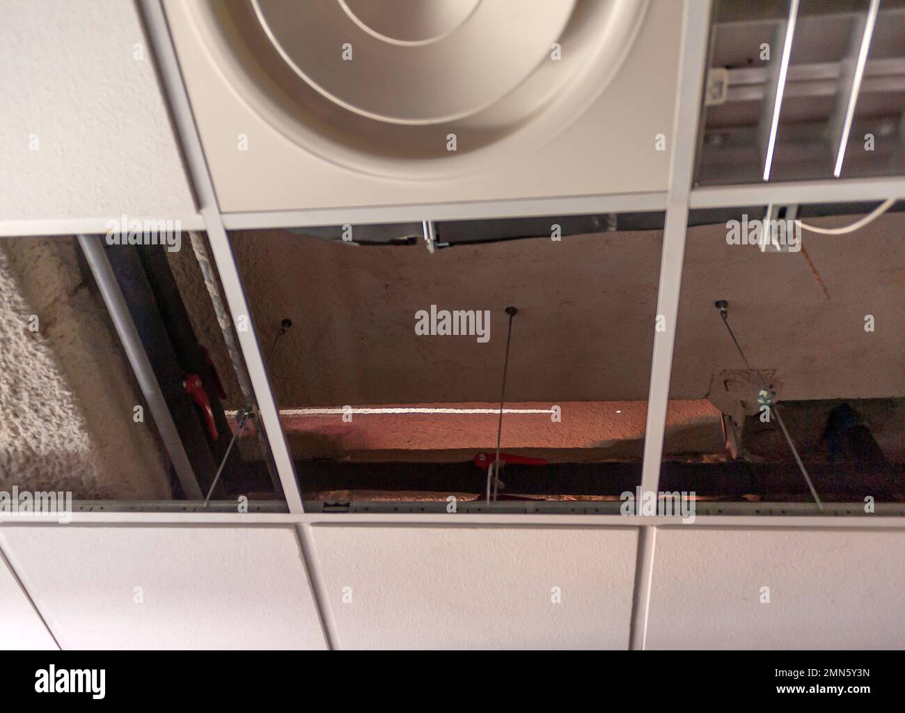 Construction worker assemble a suspended ceiling with drywall and ...
