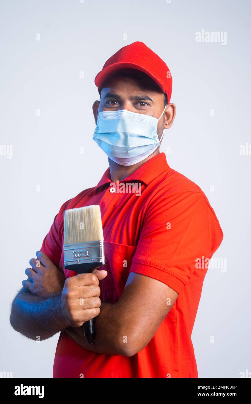 Vertical shot of painter standing with medical face mask by holding ...