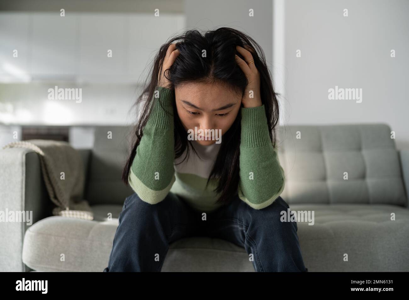 Unhappy depressed young Asian woman feeling sad and lonely after ...