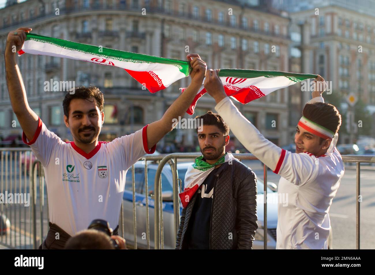 Iranian soccer fans hold Iranian national flags as they pose for a ...