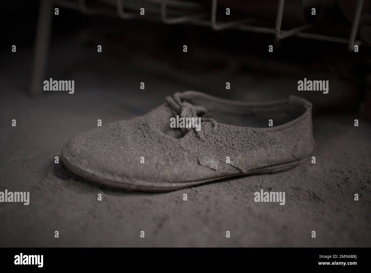 This June 9, 2018 photo shows a shoe caked in volcanic ash spewed by ...