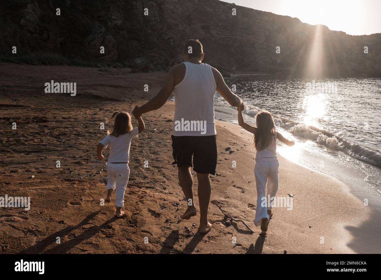 Daddy's love and care. The father holds two daughters in his arms ...