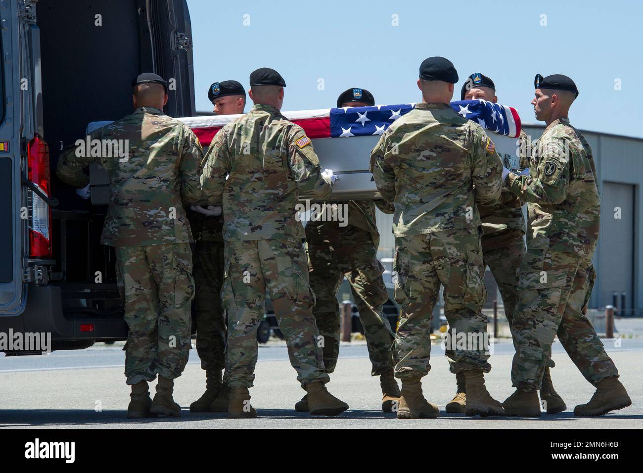 An Army carry team places the transfer case containing the remains of ...