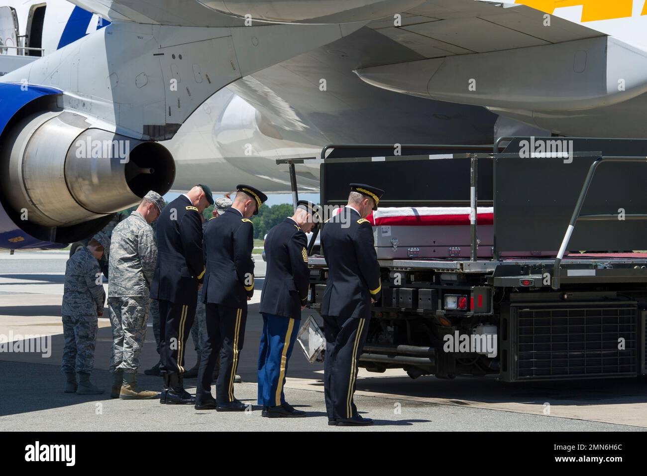 Army and Air Force Officers pray over the transfer case containing the ...