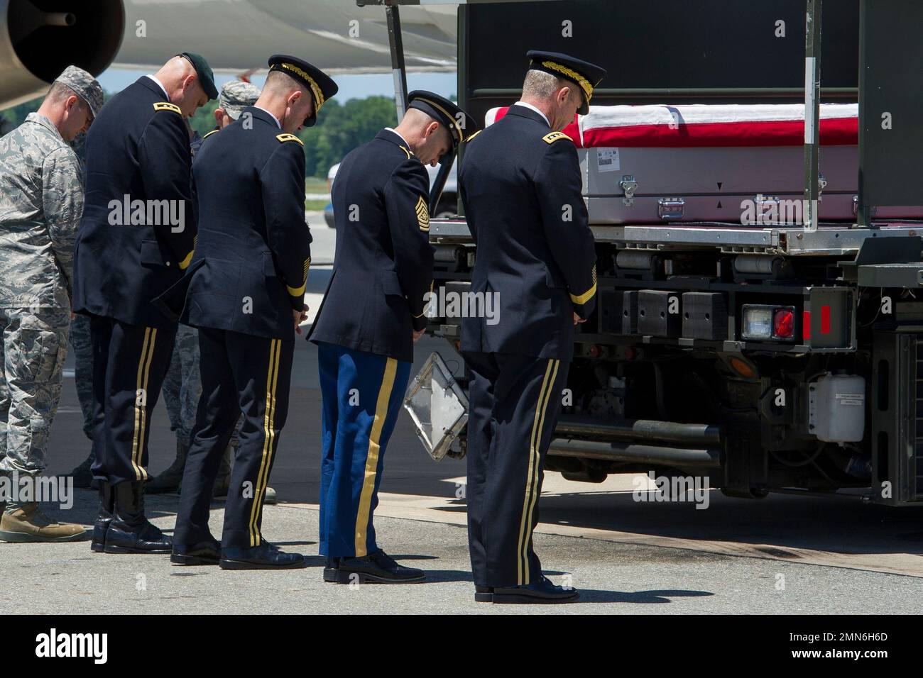 Army and Air Force Officers pray over the transfer case containing the ...