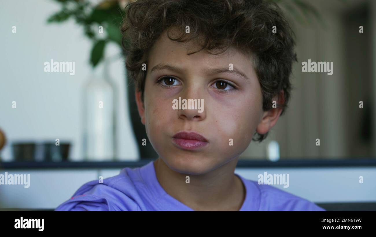 Candid kid eating cookie at breakfast table. Portrait young boy child ...