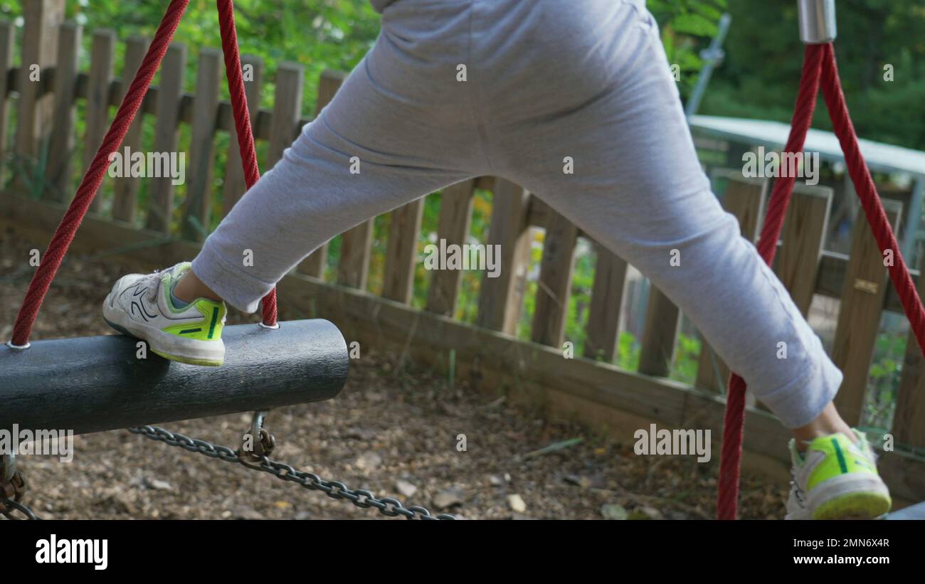 Playful little boy keeping balance at playground structure. Child ...