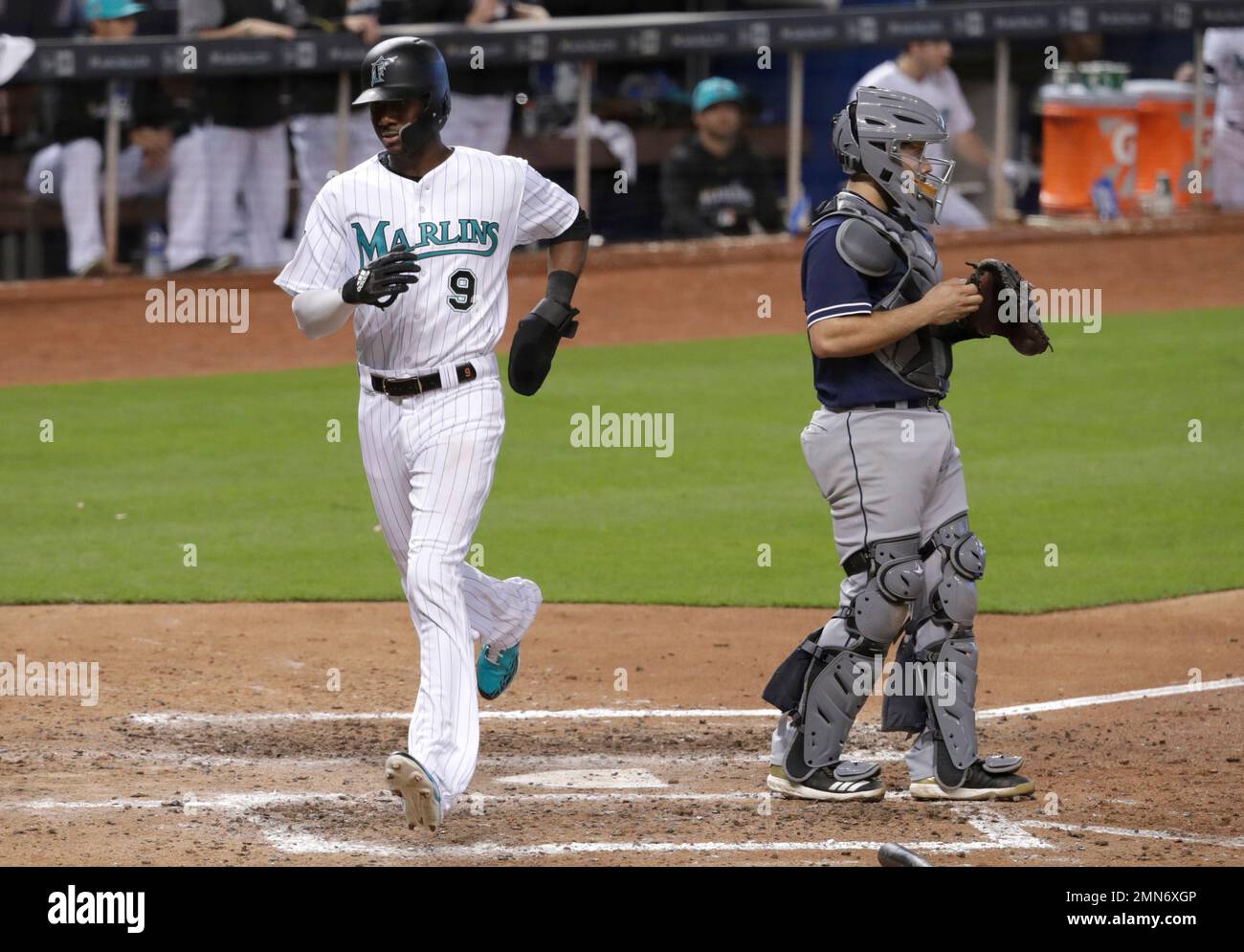 Miami Marlins' Lewis Brinson (9) runs past San Diego Padres catcher ...
