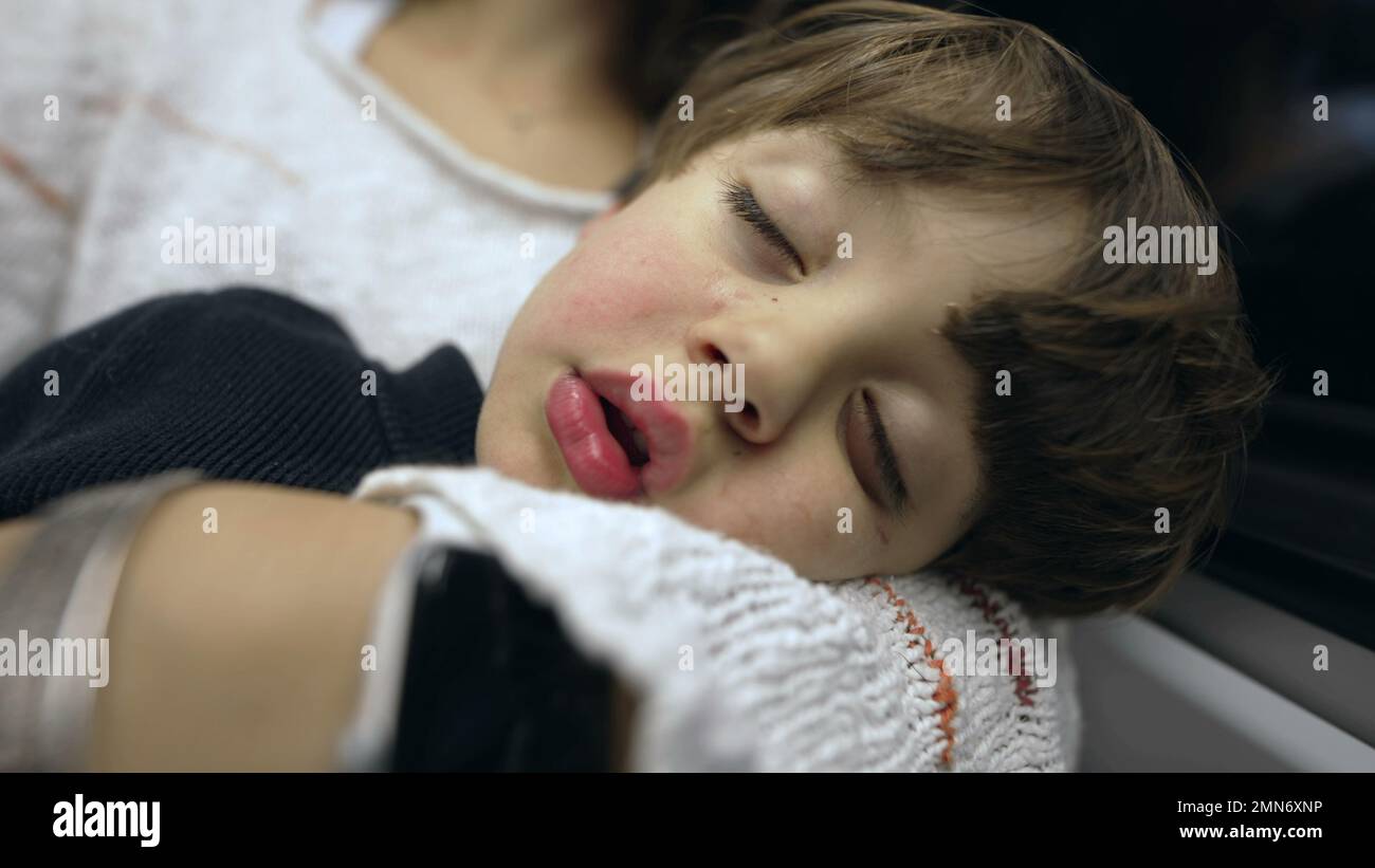 Child sleeping on mother arm inside train. Close up little boy napping ...