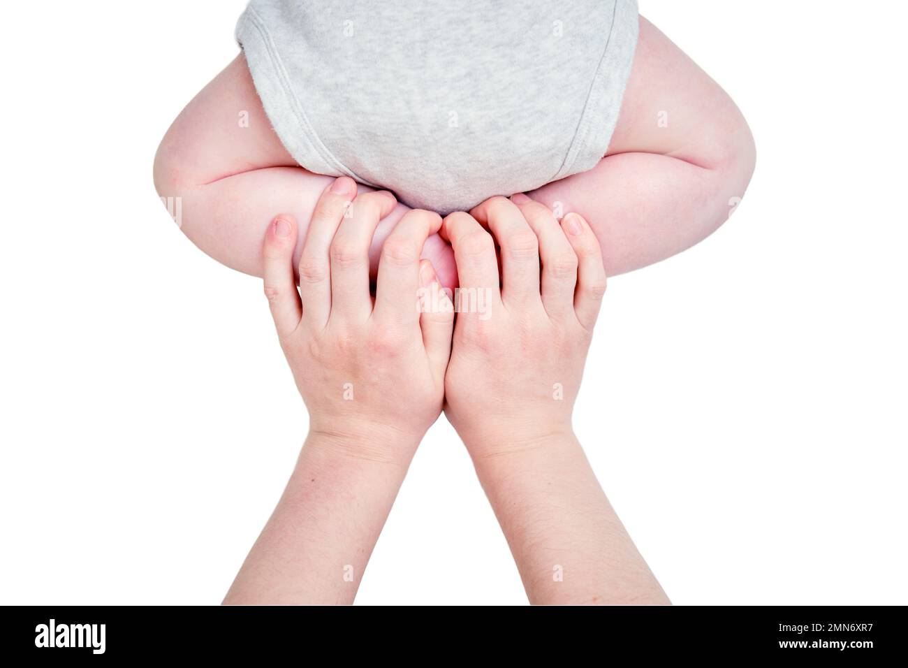 Woman mother helps to crawl infant baby by pushing off from palms of ...
