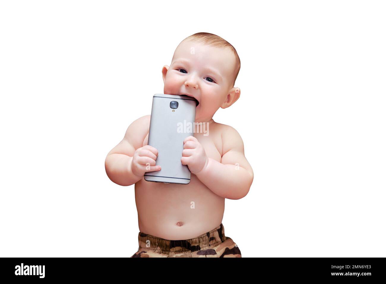 Funny happy baby boy gnaws a phone in his hands. Smiling child holds a ...