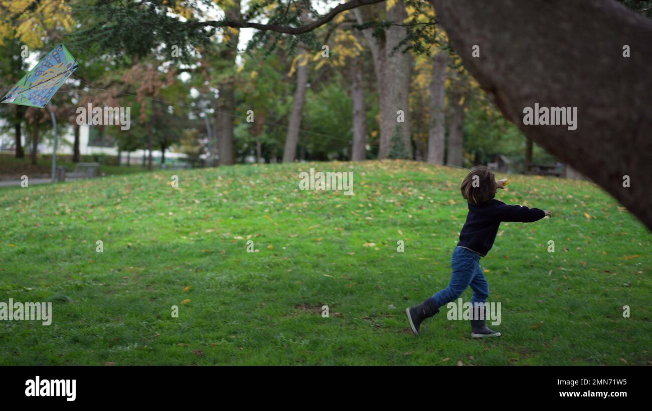 Happy active child running with kite outdoors. One small boy flying ...