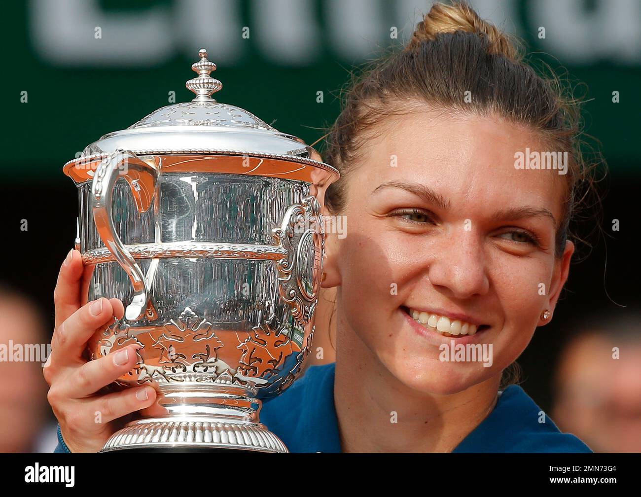 Romania's Simona Halep holds the trophy as she celebrates winning the ...