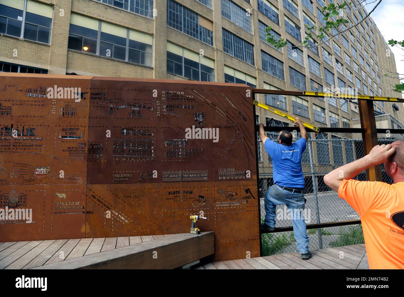 Craftsmen install a panel of the donor wall, a 75 foot long steel wall ...